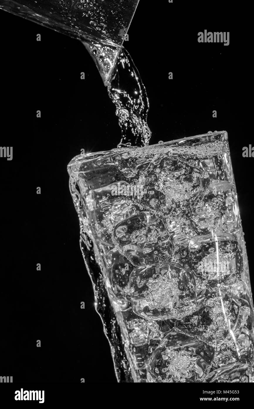 sparkling water overflow over ice cubes Stock Photo - Alamy