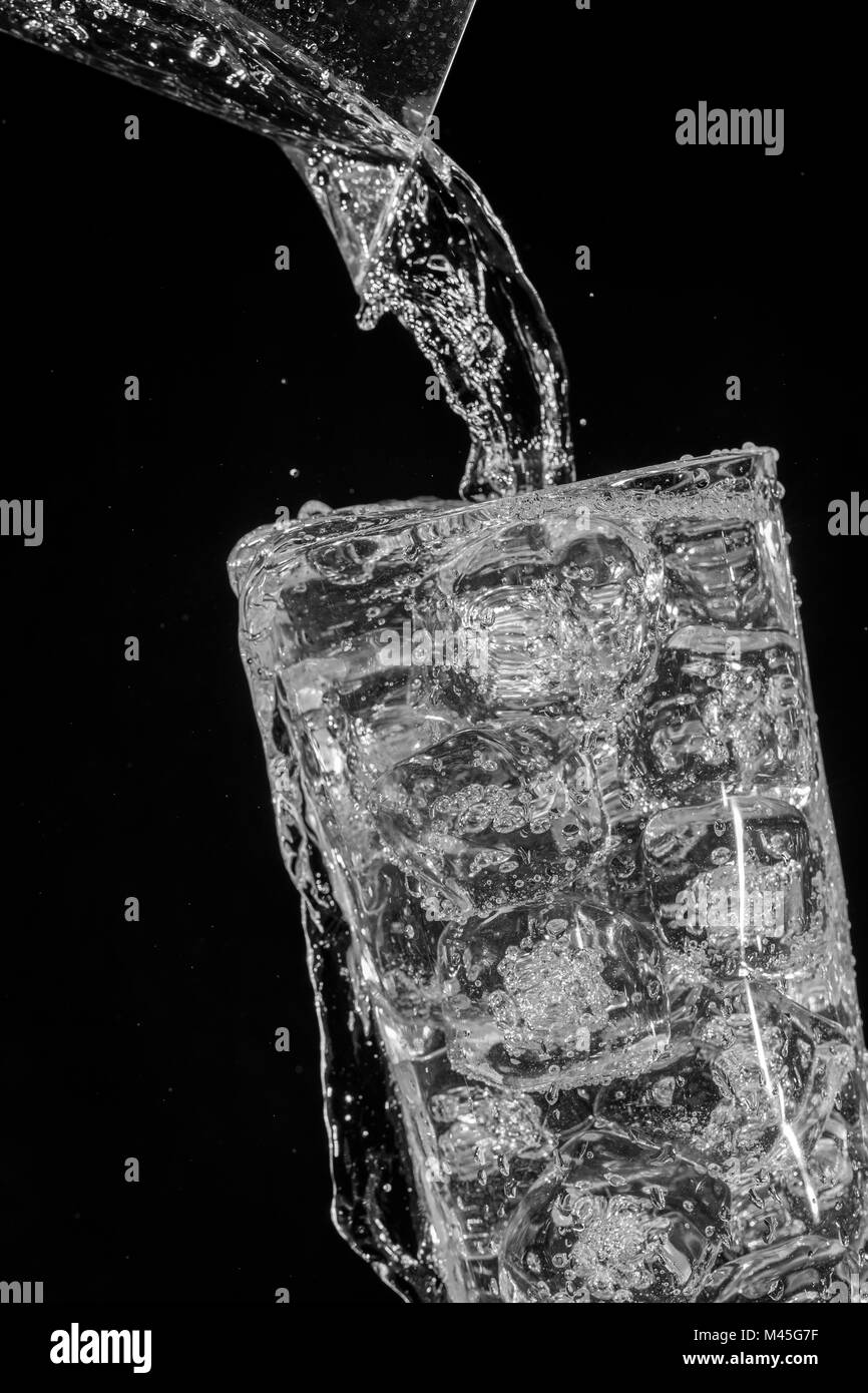 sparkling water overflow over ice cubes Stock Photo - Alamy