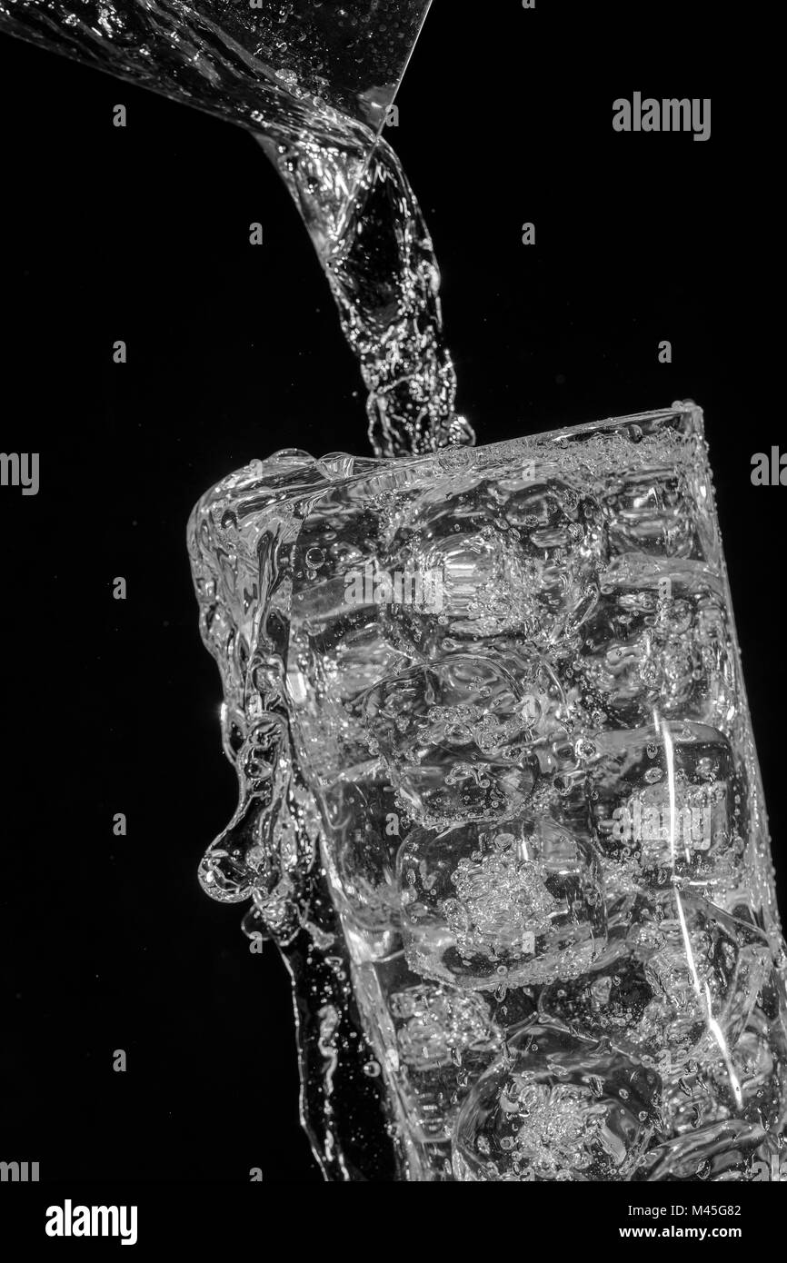 sparkling water overflow over ice cubes Stock Photo - Alamy