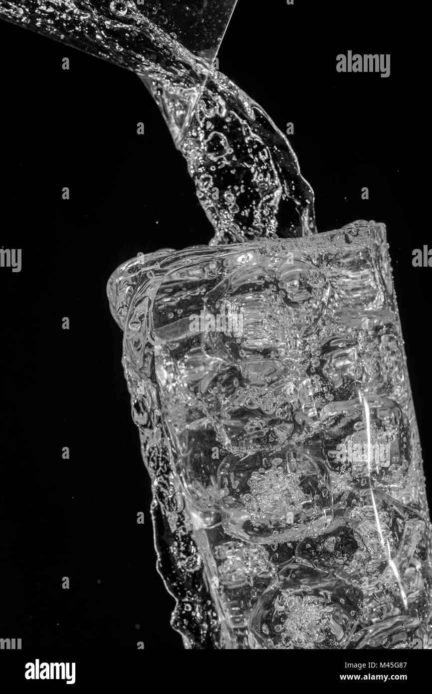 sparkling water overflow over ice cubes Stock Photo - Alamy