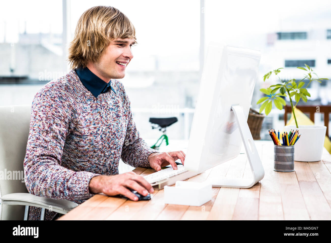 Smiling hipster businessman using his computer Stock Photo - Alamy
