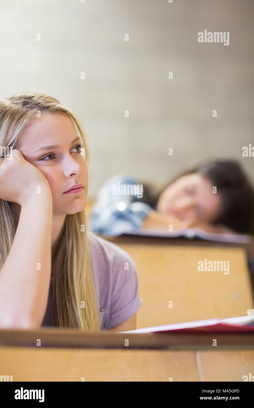 Bored student listening while classmate sleeping Stock Photo - Alamy