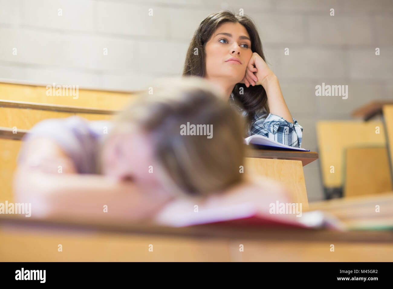 Bored student listening while classmate sleeping Stock Photo - Alamy