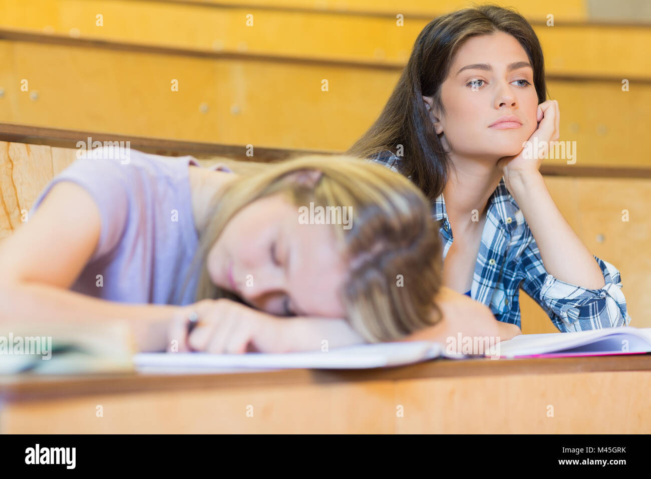 Bored student listening while classmate sleeping Stock Photo - Alamy