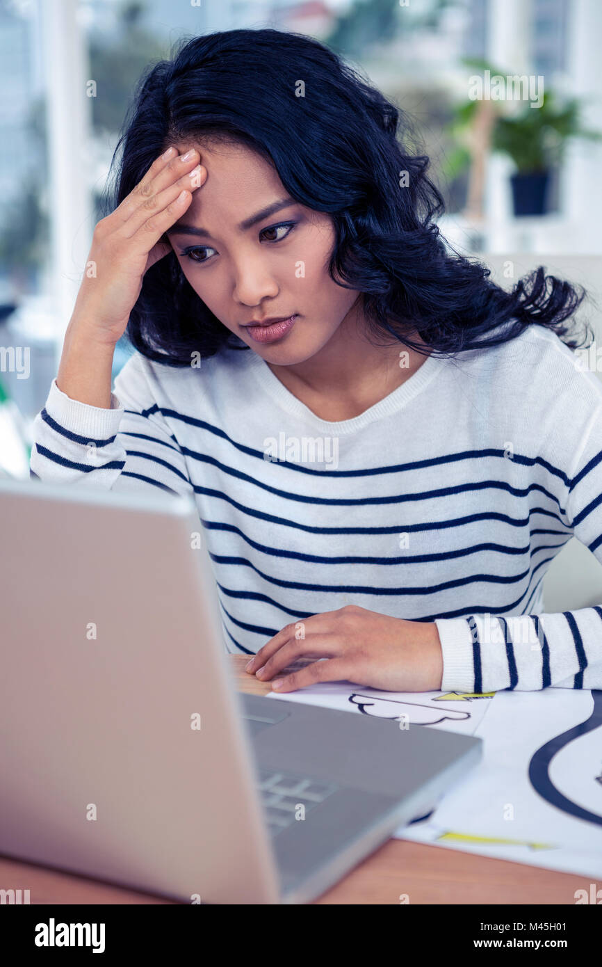 Pretty woman looking at computer monitor with hand on head Stock Photo ...