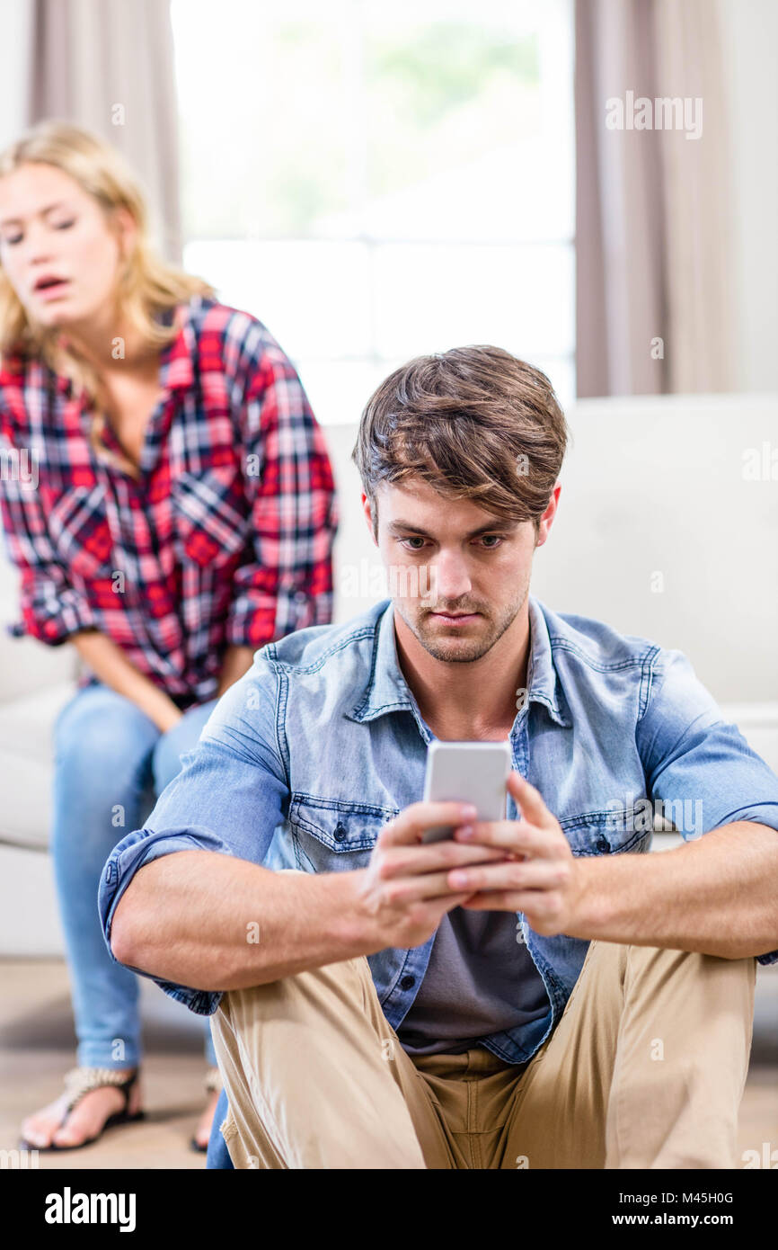 Couple sulking each other and boyfriend texting Stock Photo - Alamy