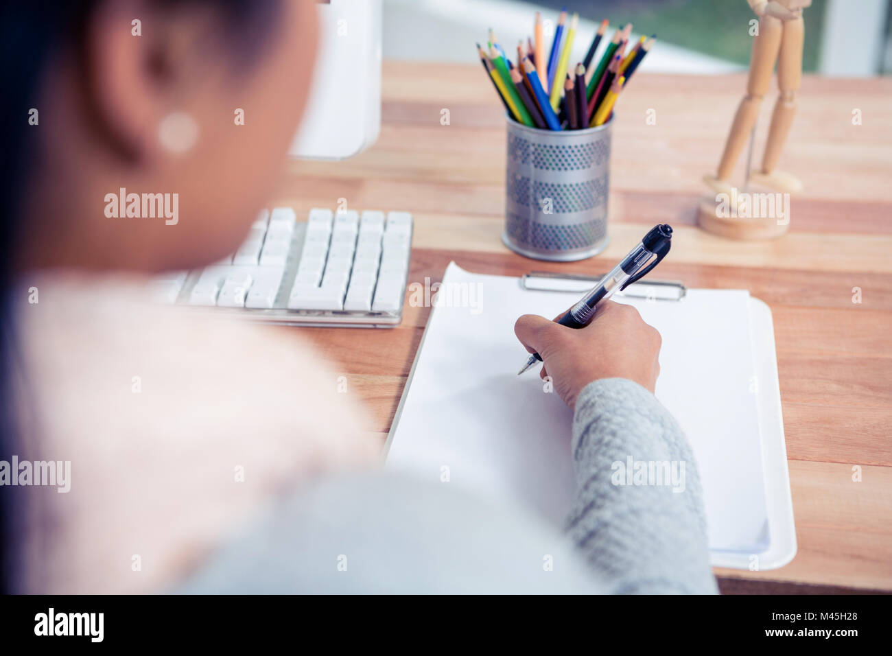 Over shoulder view of woman writing on white sheet Stock Photo - Alamy