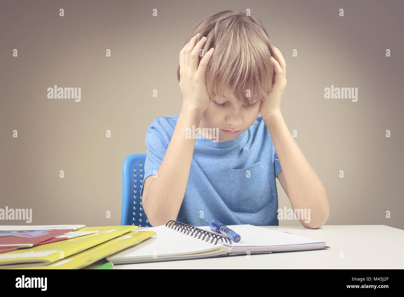 Concentrated child doing his homework at home. The boy sitting and ...