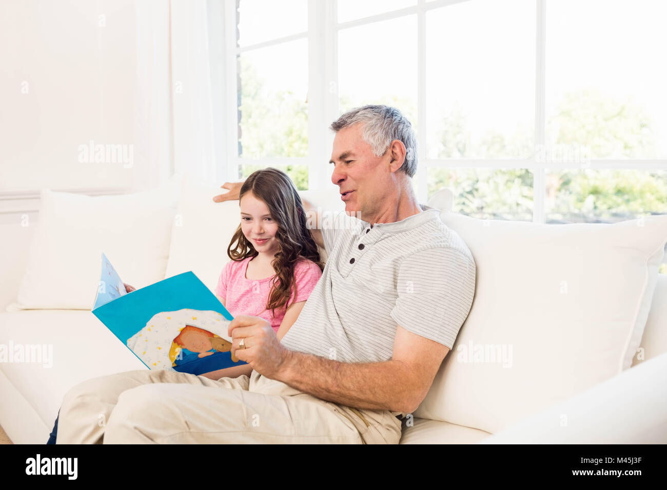 Elderly grandfather girl reading hi-res stock photography and images ...