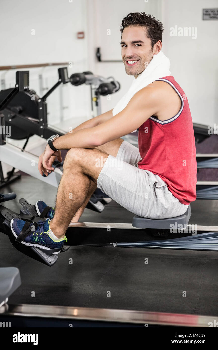 Muscular man on rowing machine smiling at the camera Stock Photo - Alamy