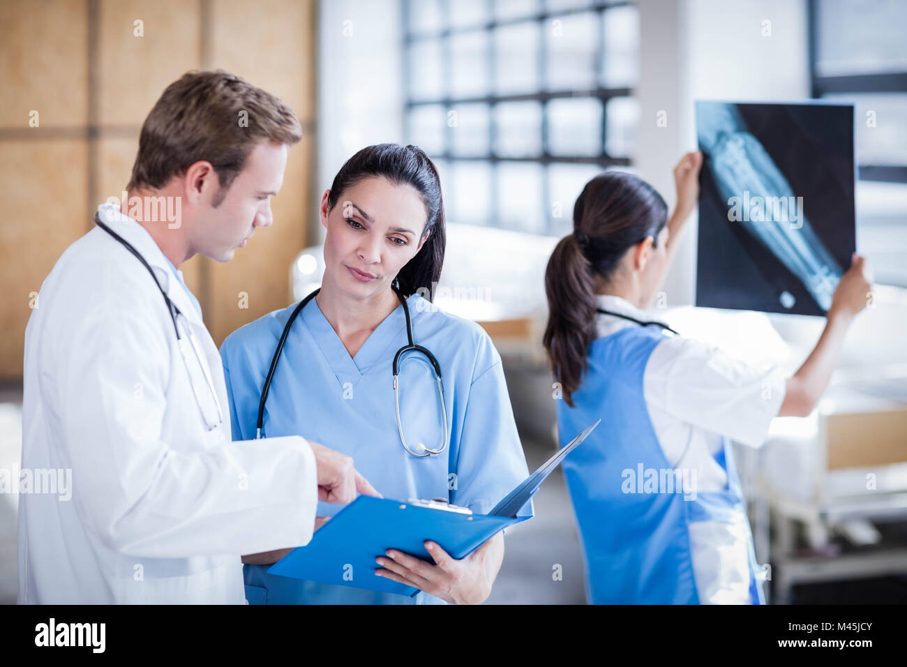 Medical team discussing the report on clipboard Stock Photo - Alamy