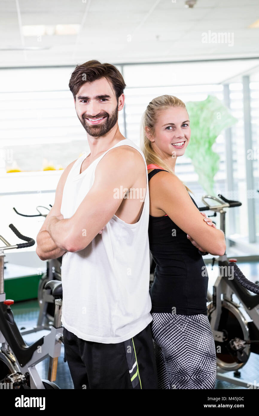 Fit couple standing back to back with arms crossed Stock Photo - Alamy