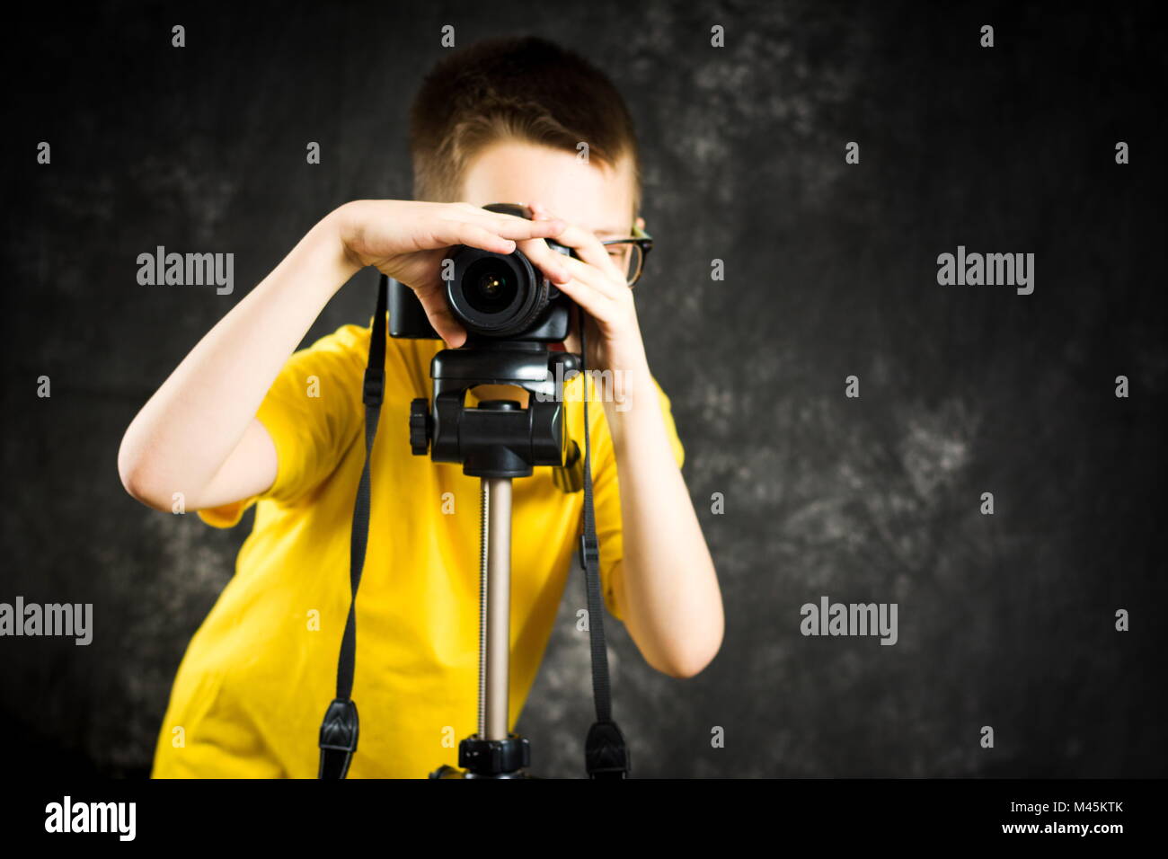 Teenage boy learning how to use a big digital camera Stock Photo - Alamy