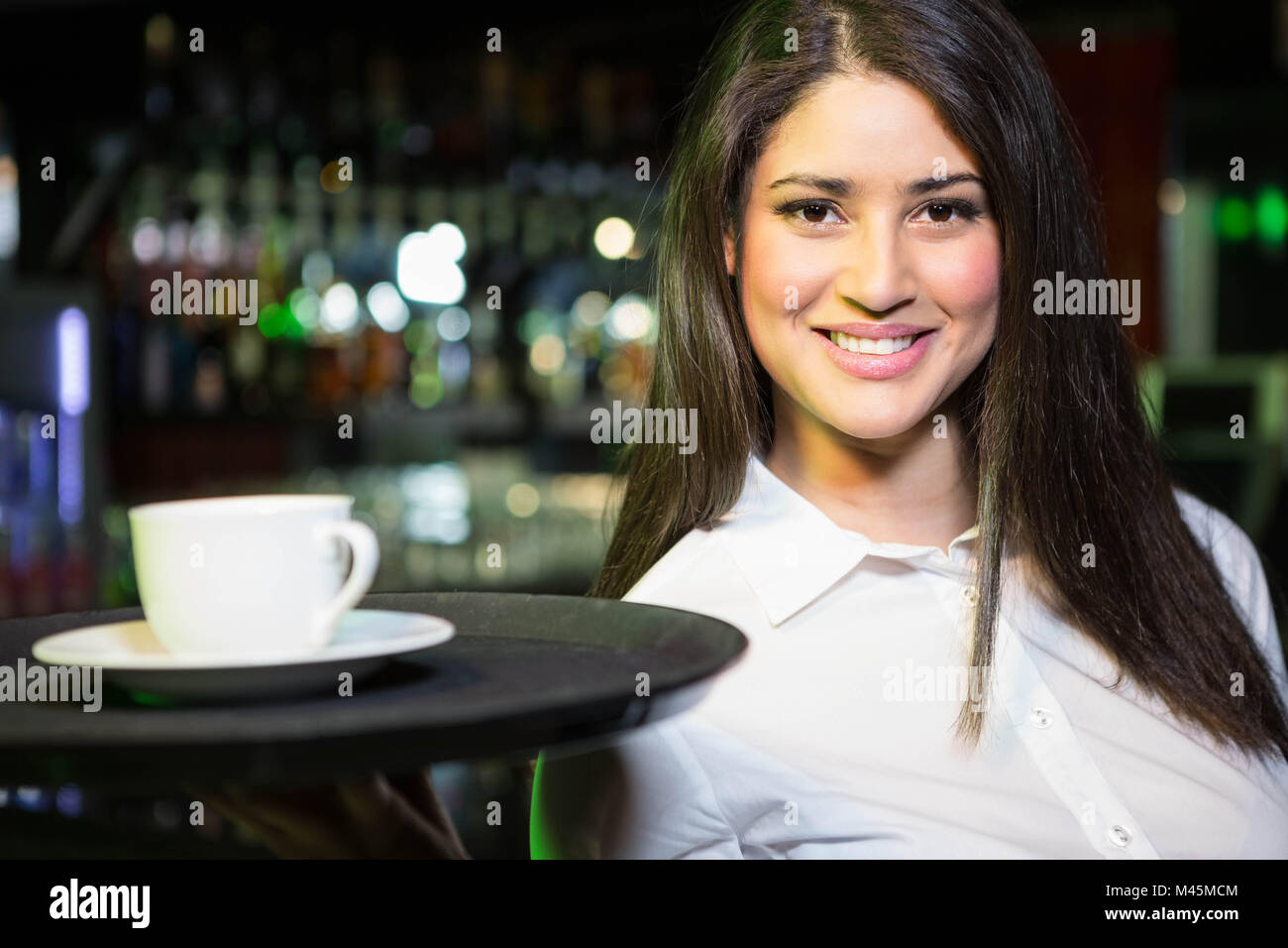 Portrait of pretty waitress serving a cup of coffee Stock Photo - Alamy