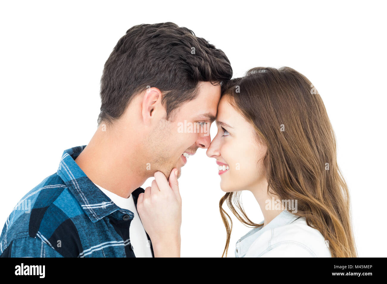 Couple standing head against head and holding chin Stock Photo - Alamy