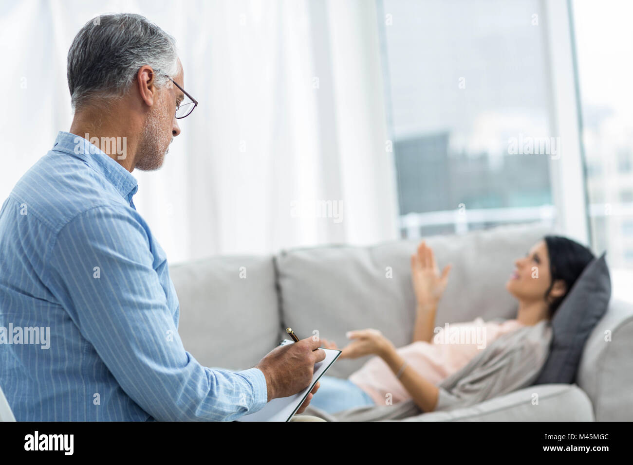 Doctor writing on notepad while consulting pregnant woman Stock Photo ...