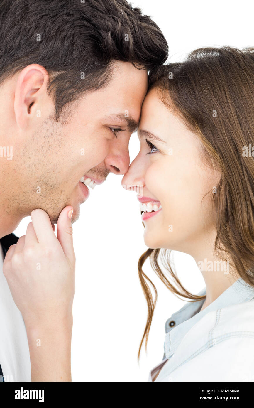 Couple standing head against head and holding chin Stock Photo - Alamy