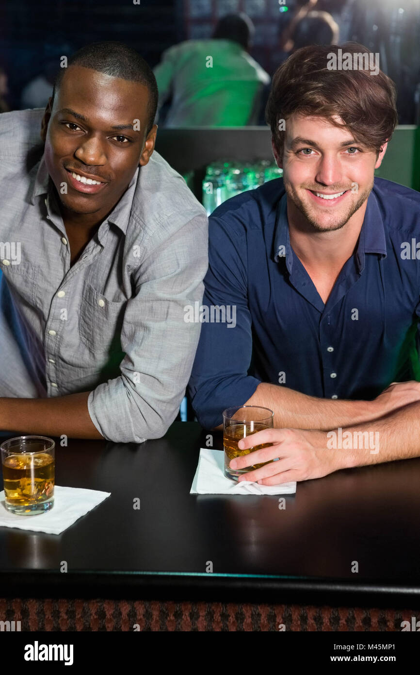 Portrait of two men having whiskey at bar counter Stock Photo - Alamy