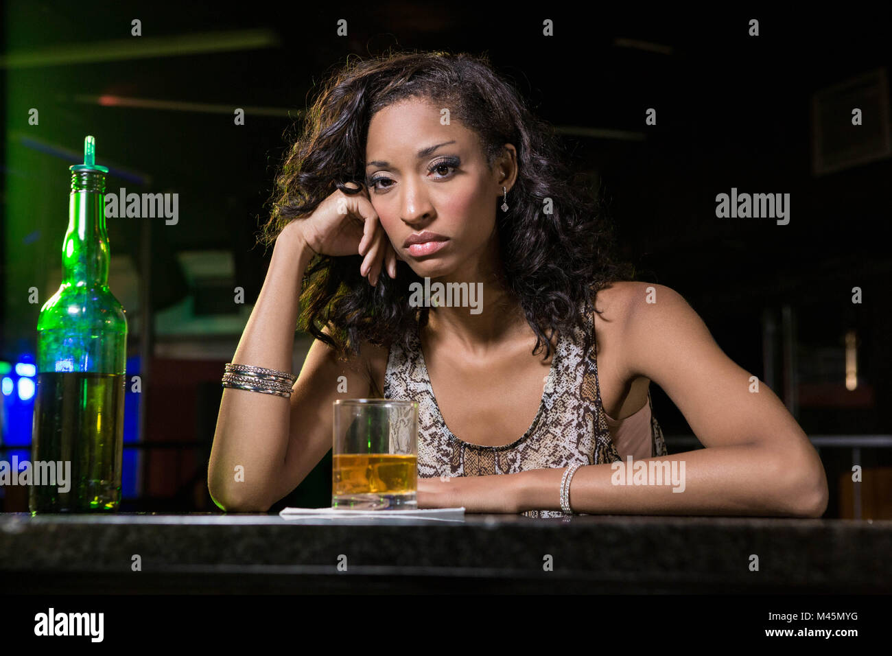 Depressed woman having whiskey at bar counter Stock Photo - Alamy