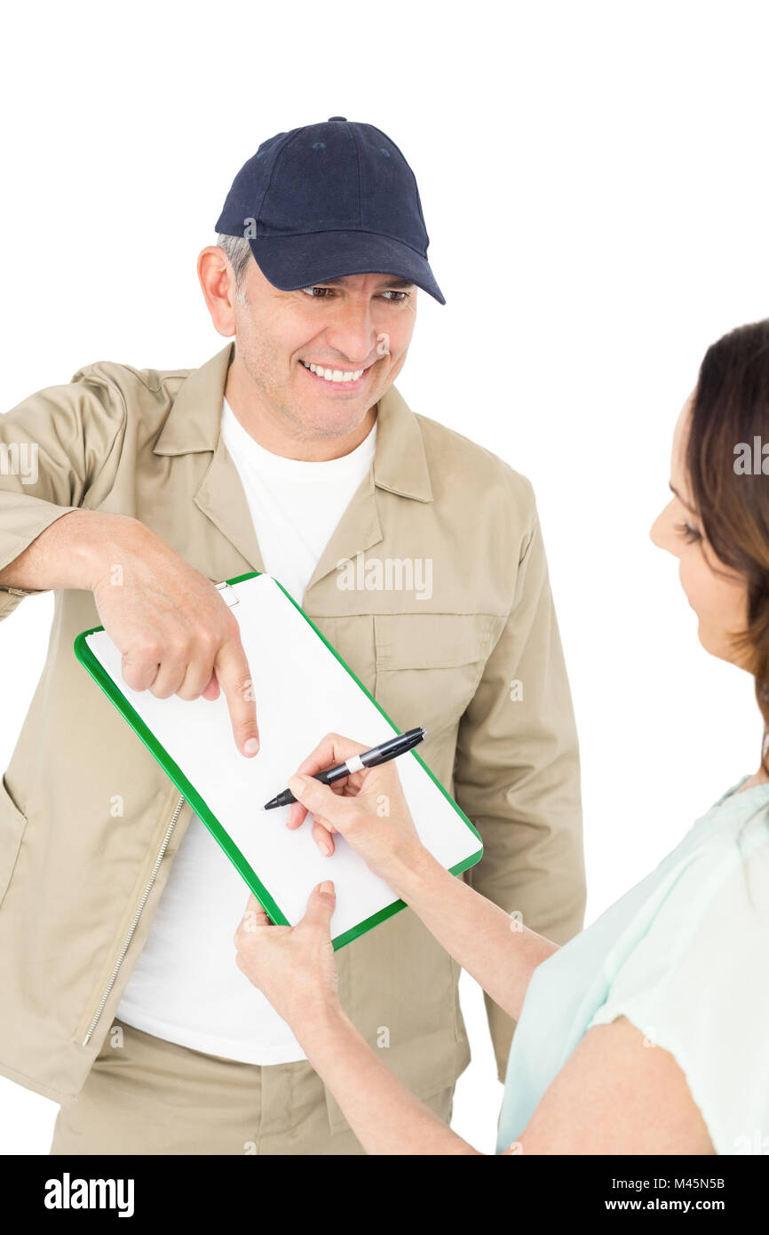 Female customer signing on paper with delivery man Stock Photo - Alamy