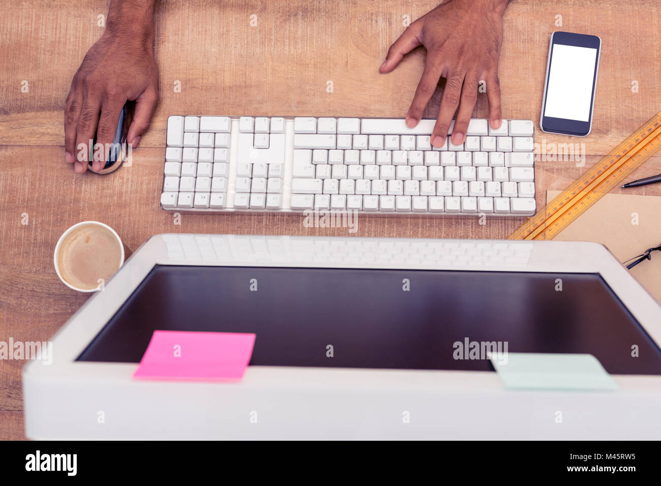 Businessman using computer while working at desk Stock Photo - Alamy