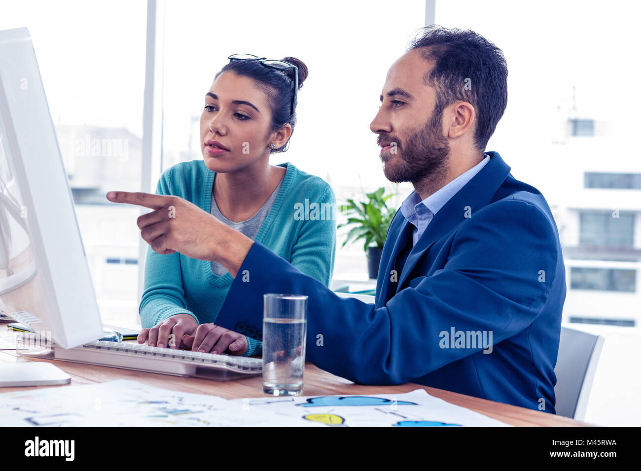 Serious business people discussing over computer Stock Photo - Alamy