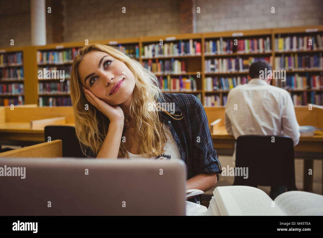 Smiling student working while using her laptop Stock Photo - Alamy