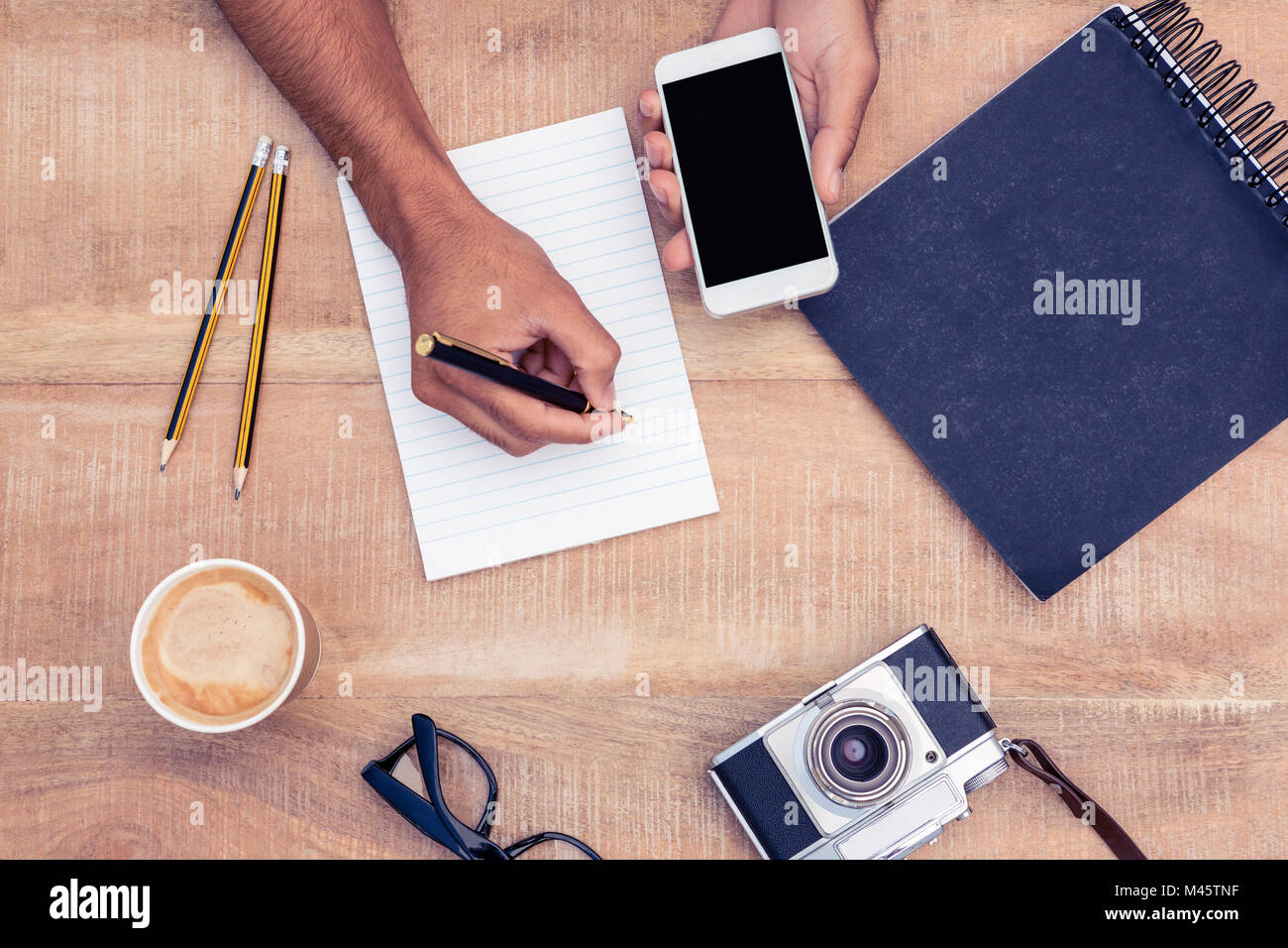 Overhead view of businessman writing on notepad Stock Photo - Alamy