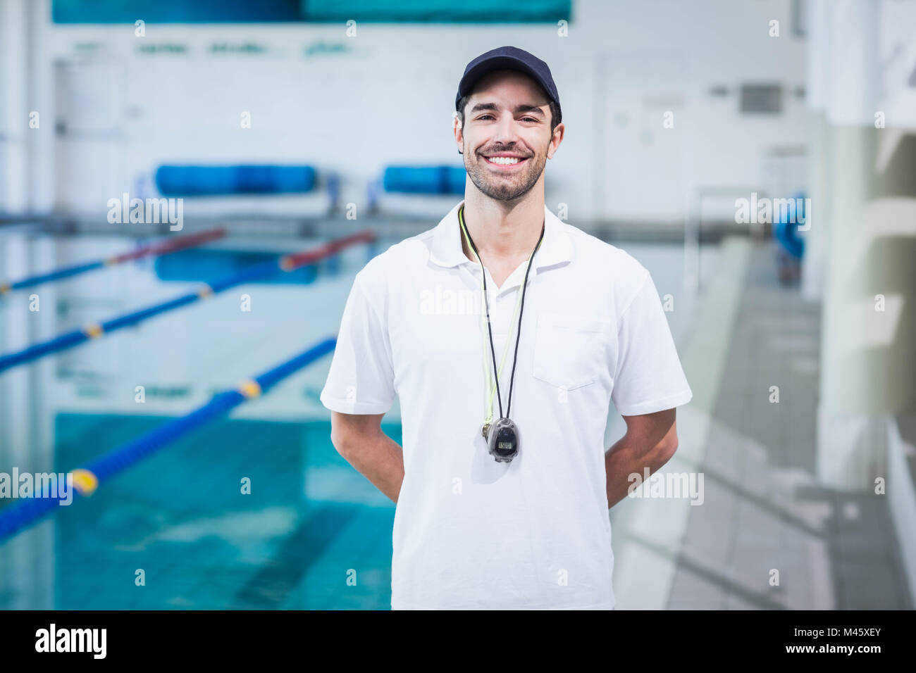 Handsome trainer standing with hands on the back Stock Photo - Alamy