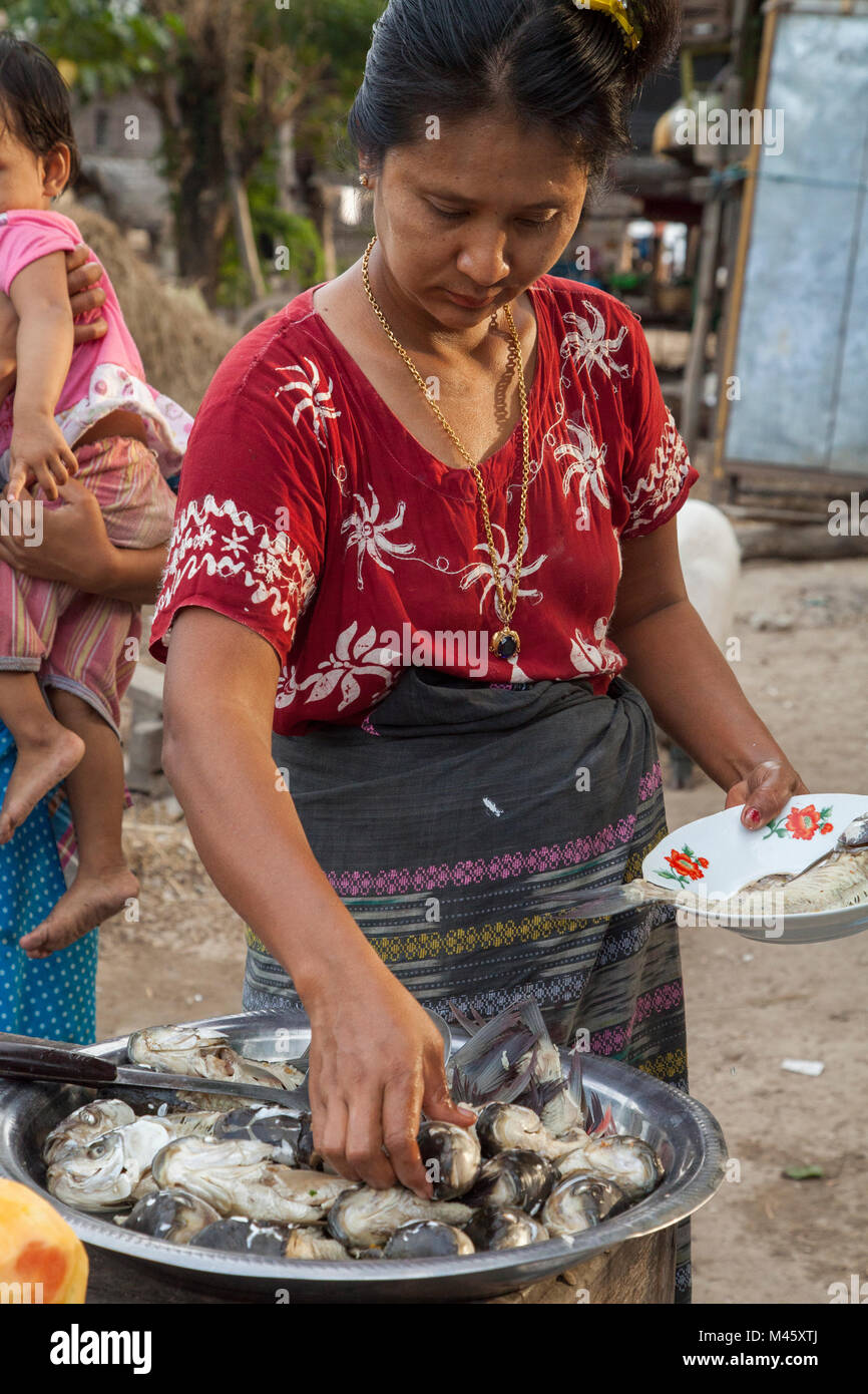 Woman eating and cooking fish in Bagan Myanmar Stock Photo - Alamy