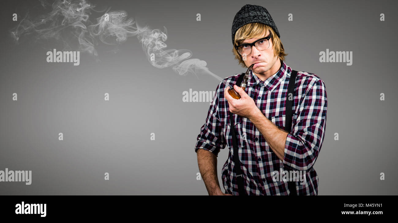 Composite image of serious blond hipster smoking a pipe Stock Photo - Alamy
