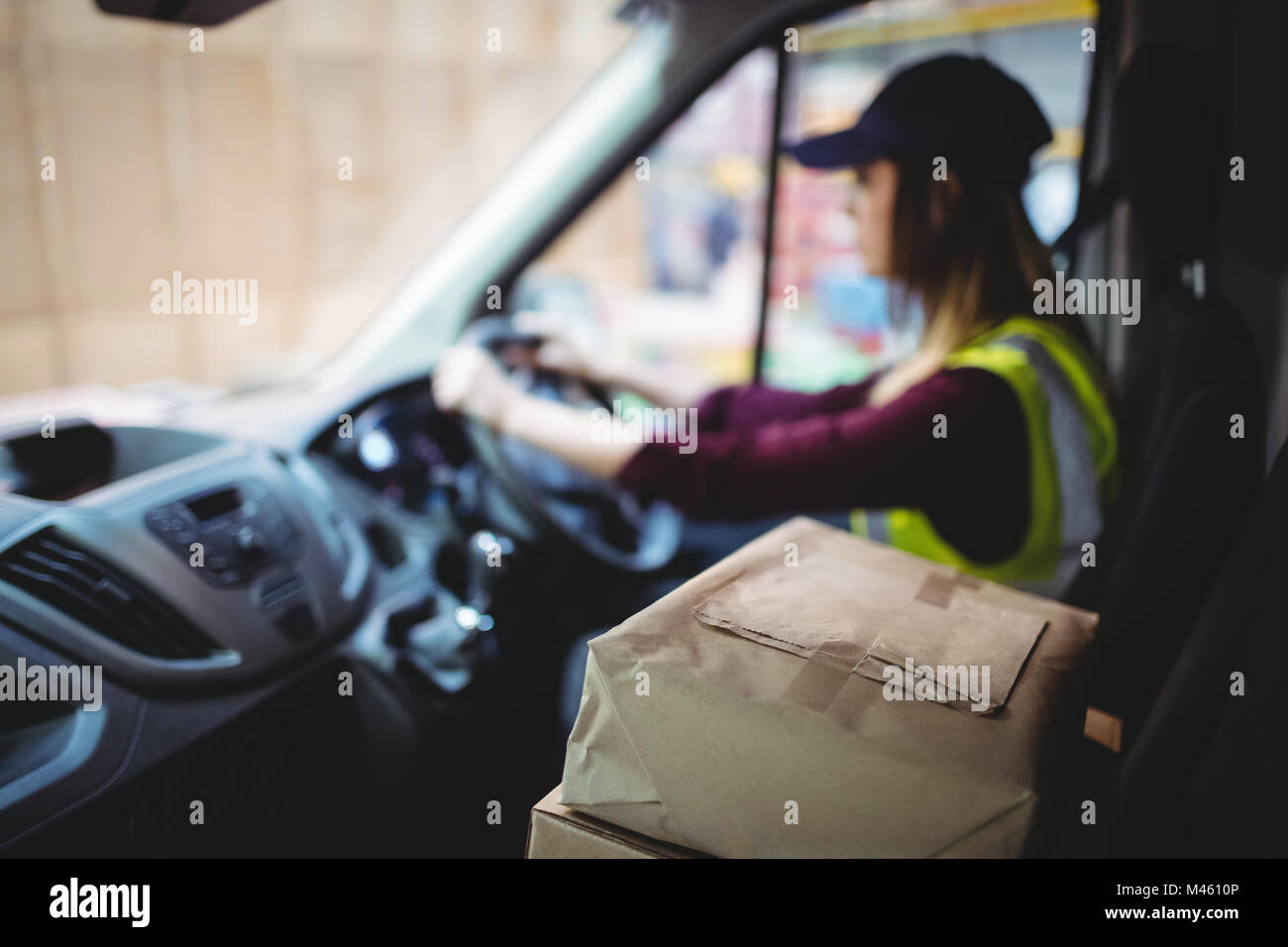 Delivery driver driving van with parcels on seat Stock Photo - Alamy