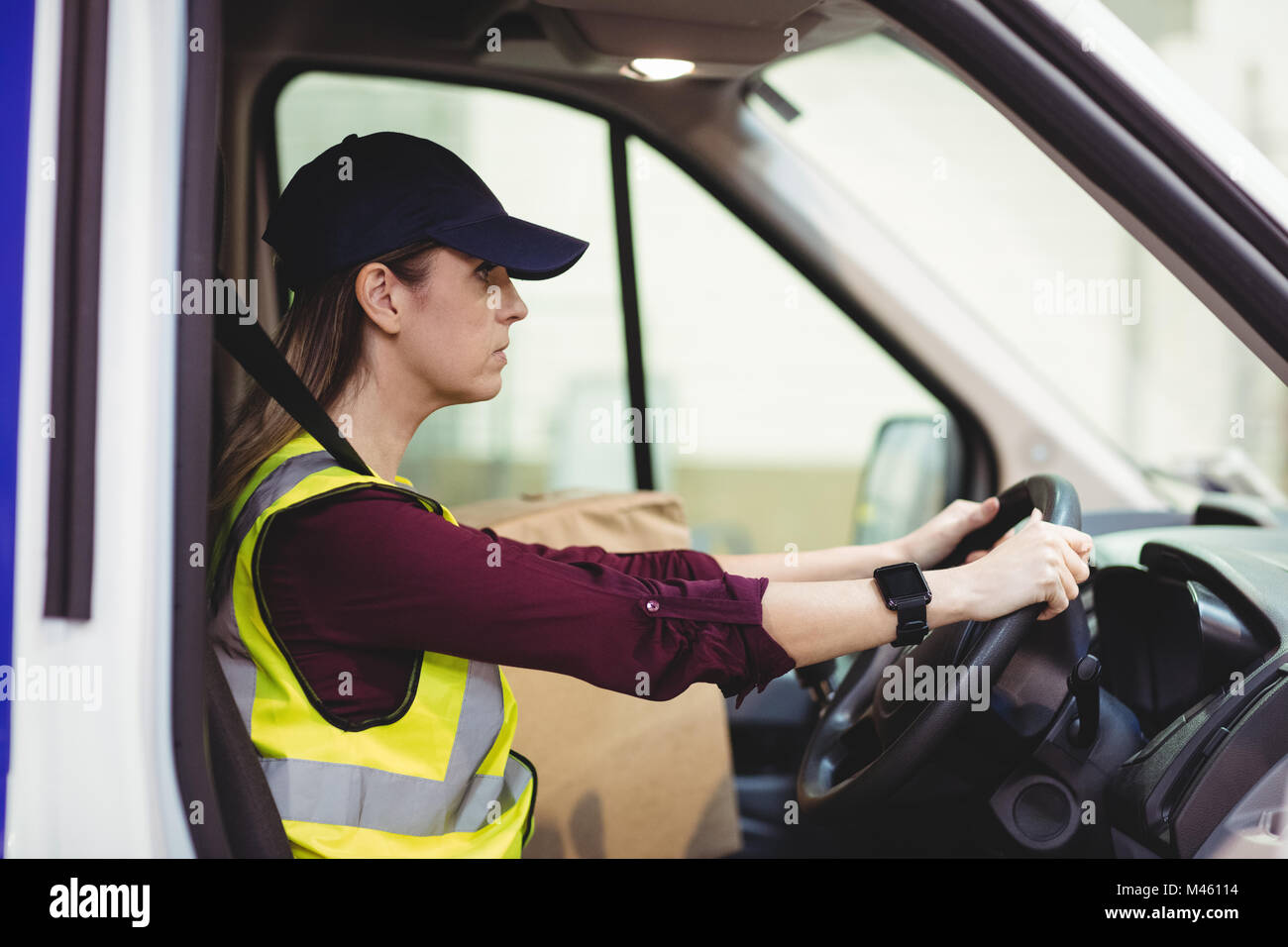 Delivery driver driving van with parcels on seat Stock Photo - Alamy