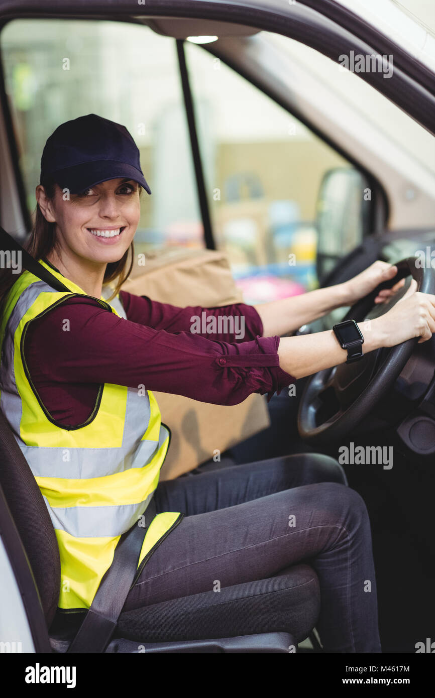 Delivery driver driving van with parcels on seat Stock Photo - Alamy