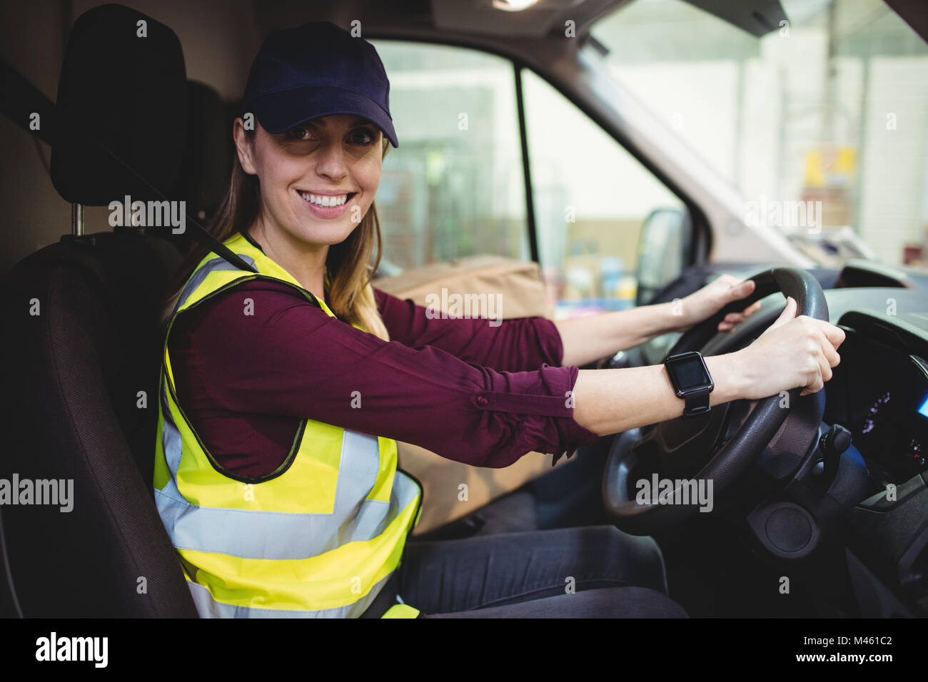 Delivery driver driving van with parcels on seat Stock Photo - Alamy