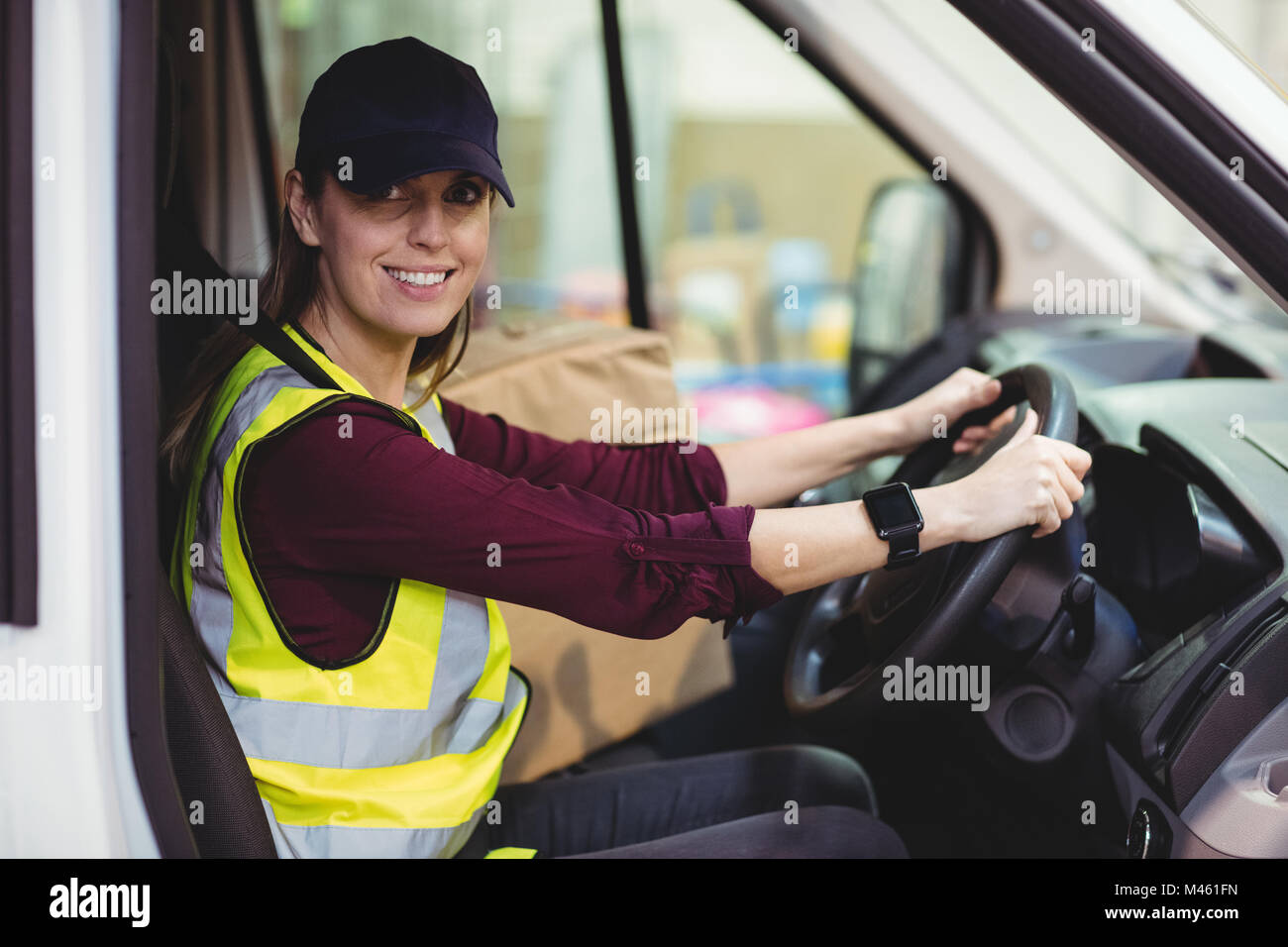 Delivery driver driving van with parcels on seat Stock Photo - Alamy