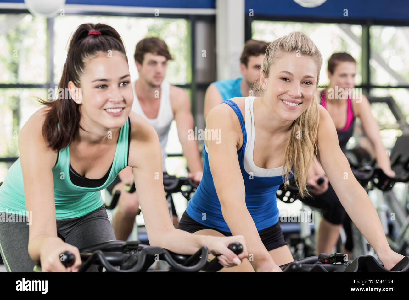 Fit group of people using exercise bike together Stock Photo - Alamy