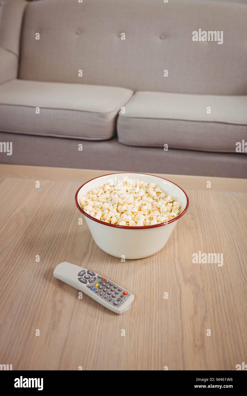 Bowl of popcorn and television remote on table Stock Photo - Alamy