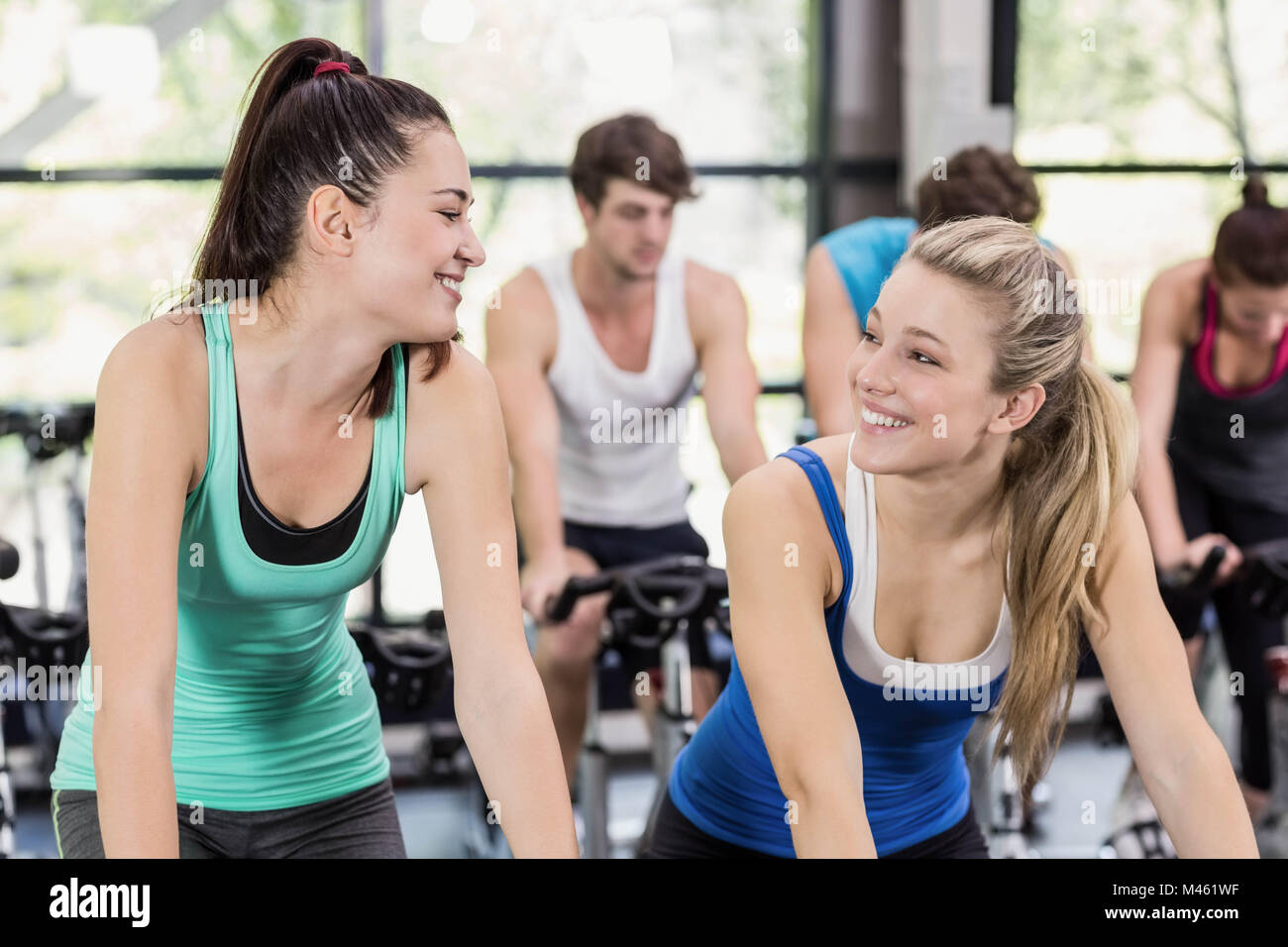 Fit group of people using exercise bike together Stock Photo - Alamy