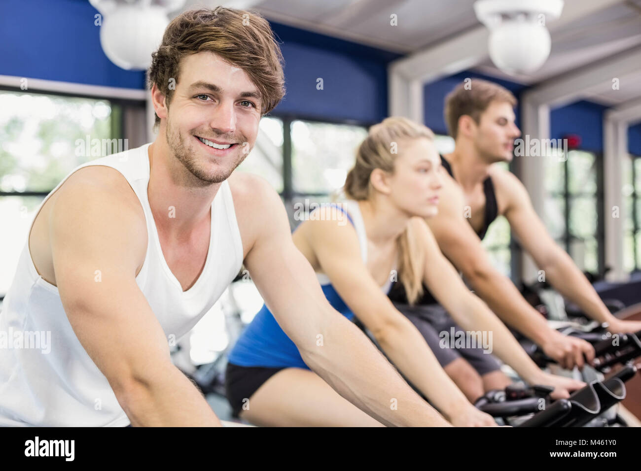 Fit group of people using exercise bike together Stock Photo - Alamy