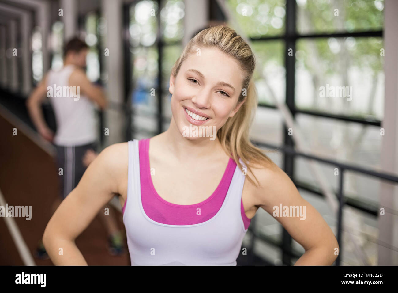 Smiling athletic woman posing with hands on hips Stock Photo - Alamy