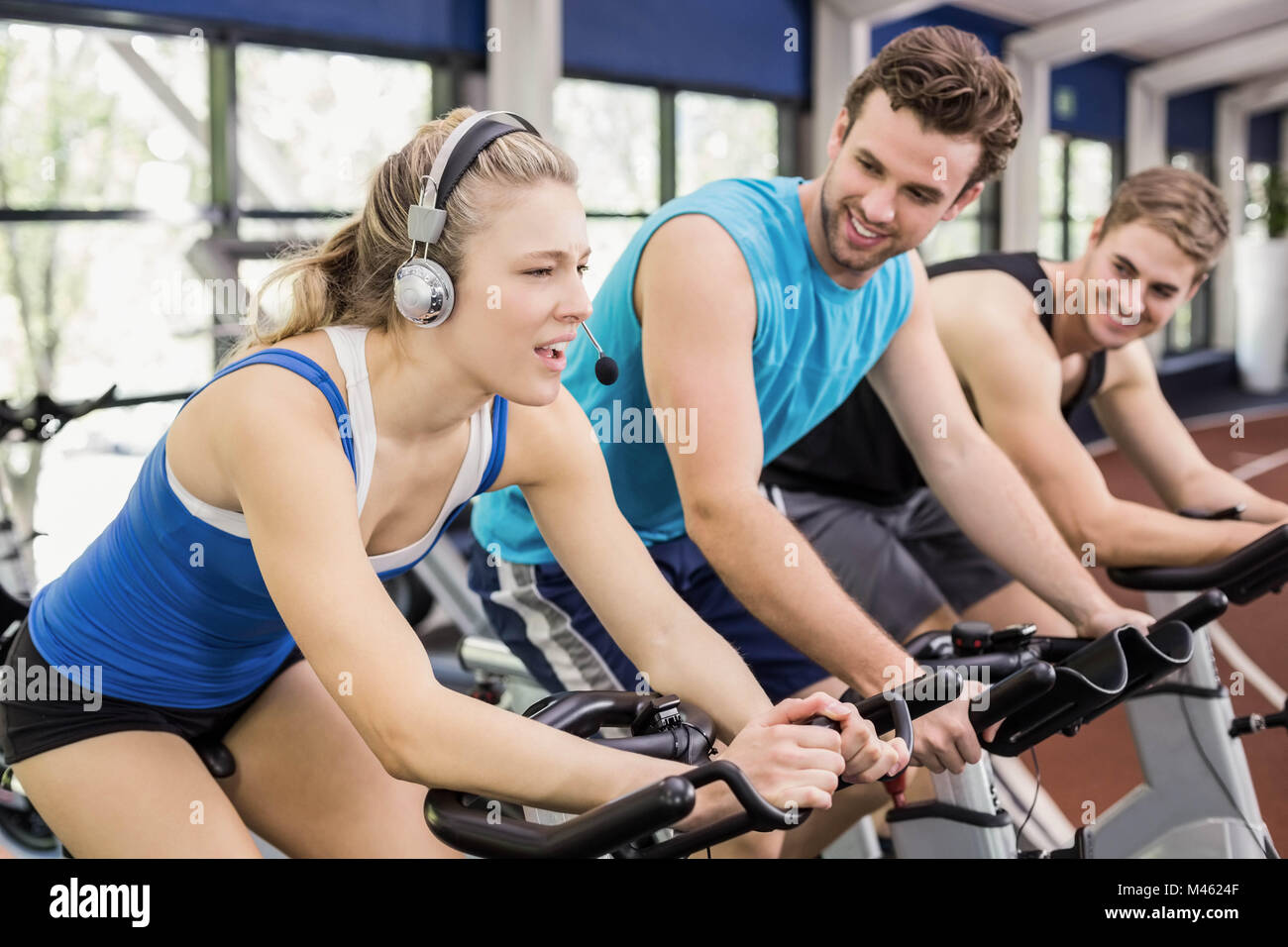 Fit group of people using exercise bike together Stock Photo - Alamy