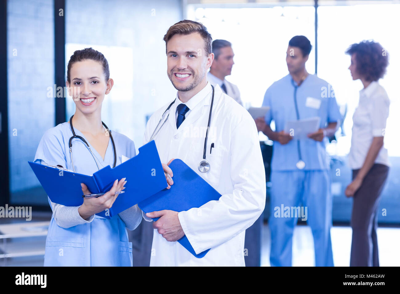 Doctors with medical report looking at camera and smiling Stock Photo ...