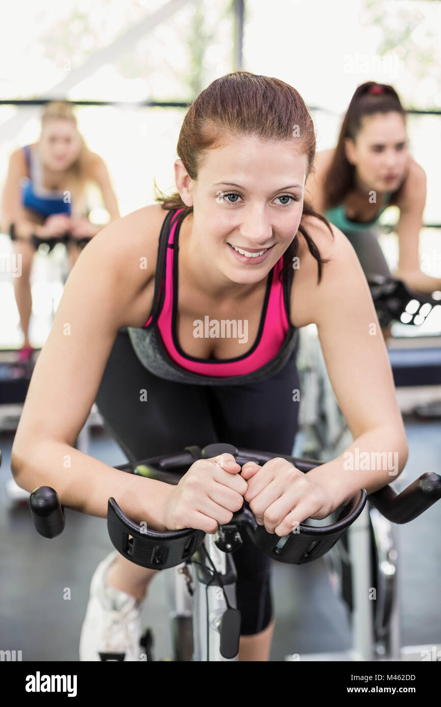 Fit group of people using exercise bike together Stock Photo - Alamy
