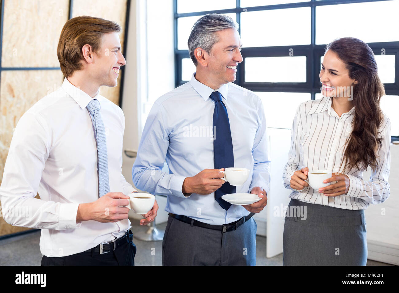 Businesspeople interacting in office during breaktime Stock Photo - Alamy