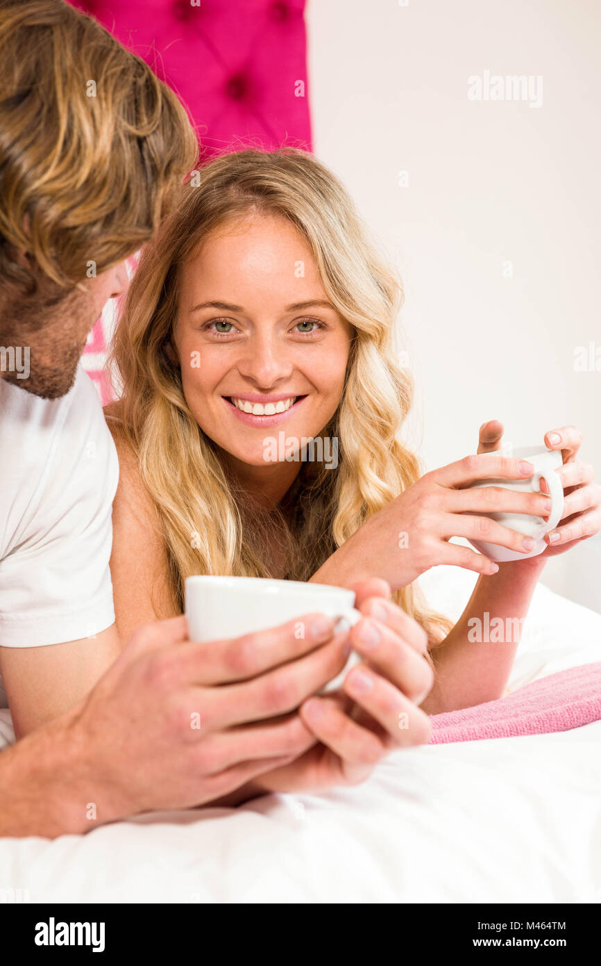 Cute couple relaxing on their bed and having coffee Stock Photo - Alamy