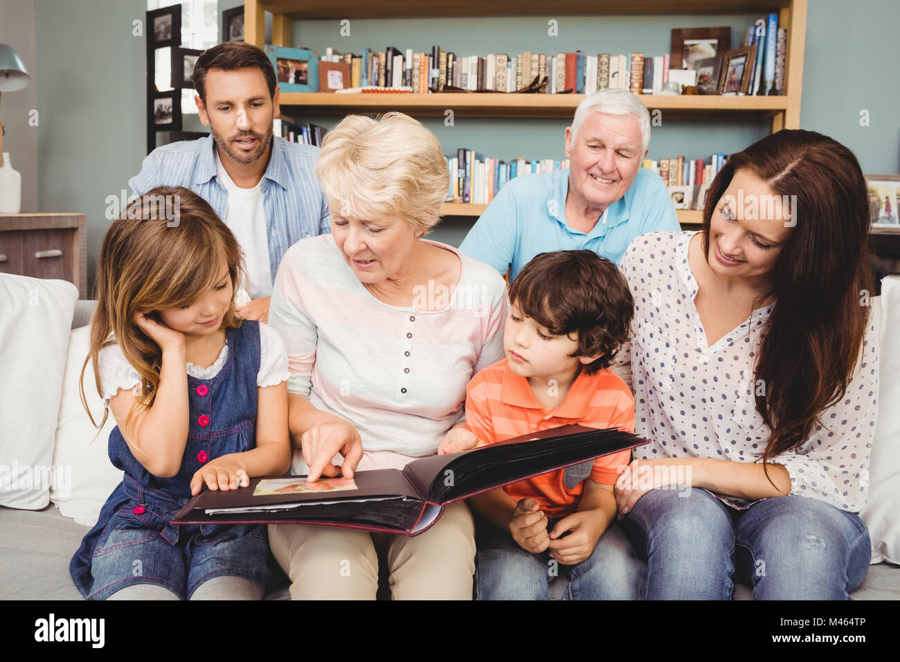 Smiling family with grandparents with photo album Stock Photo - Alamy
