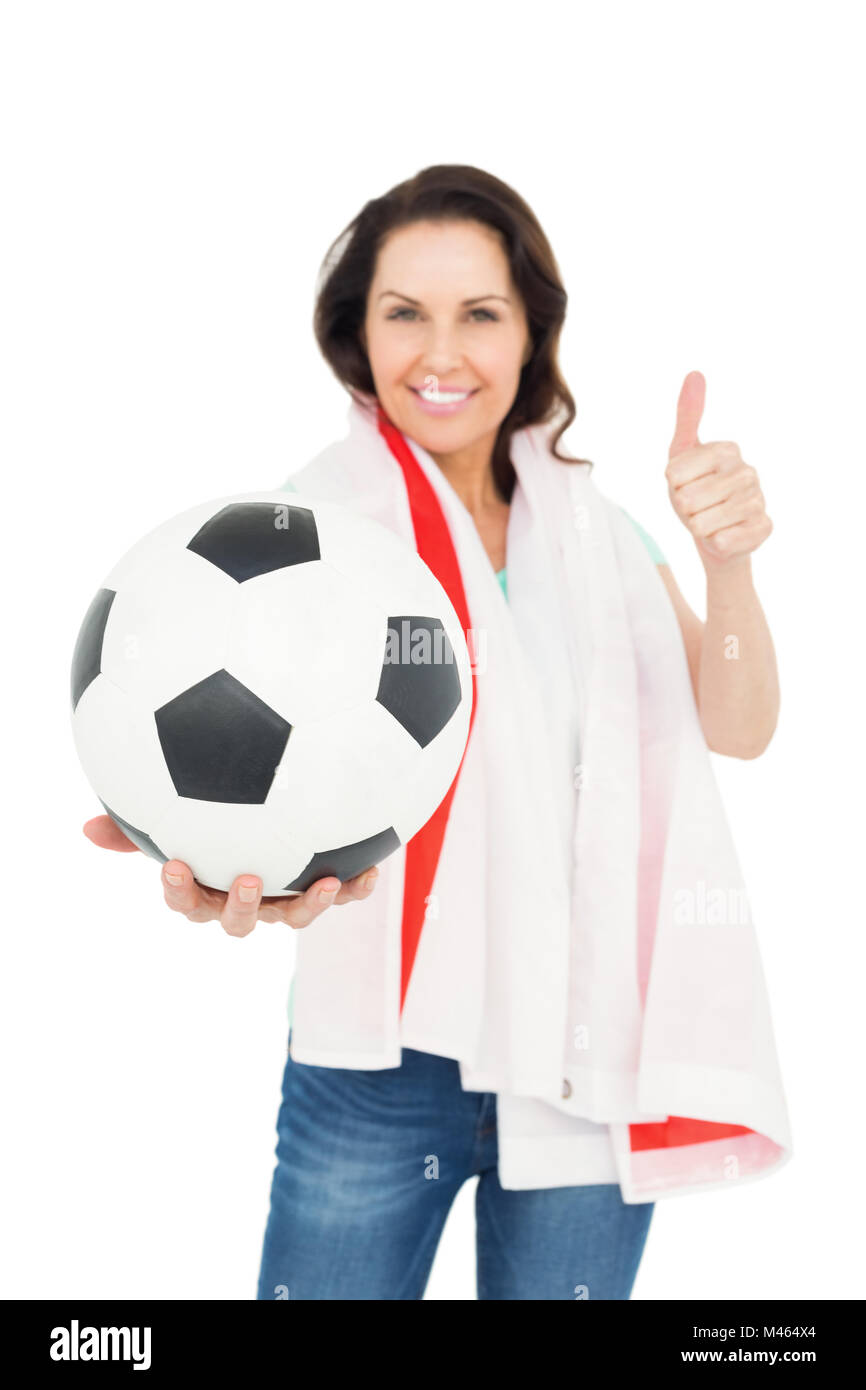Pretty brunette with thumbs up holding soccer ball Stock Photo - Alamy