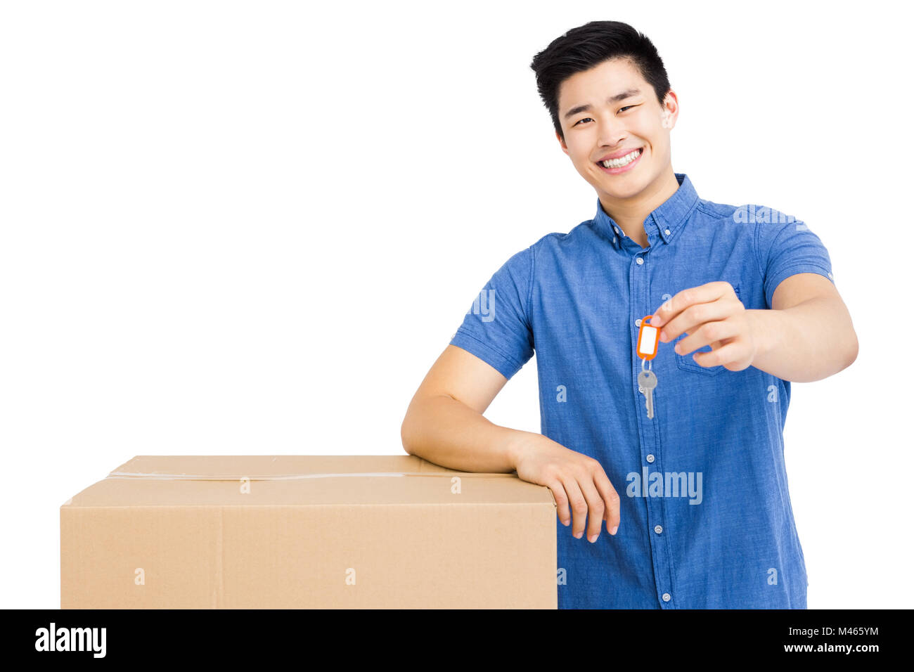 Young man leaning on cardboard box and holding a key Stock Photo - Alamy