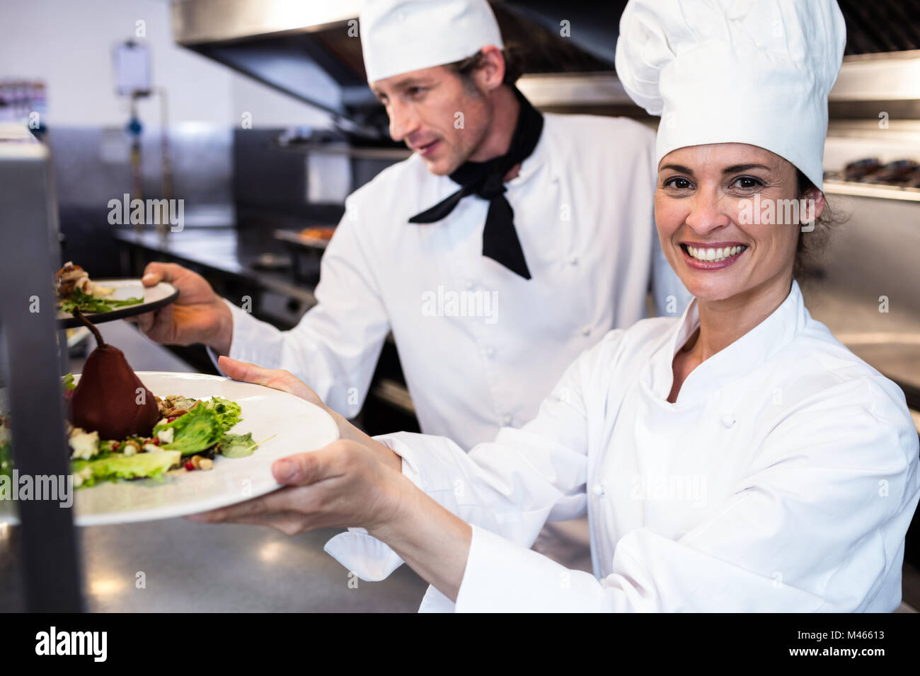 Chefs handing dinner plates through order station Stock Photo - Alamy